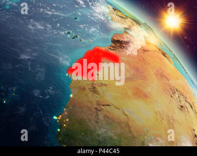 Sunrise above Western Sahara highlighted in red on model of planet Earth in space with visible ...