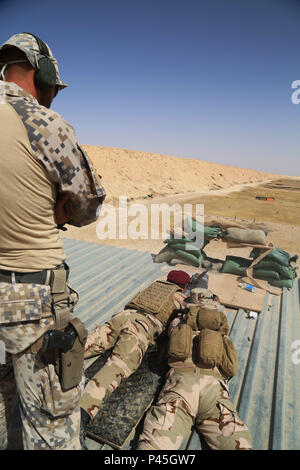 Iraqi soldiers establish security from behind an earthen berm during a ...