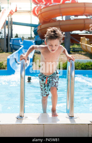 A boy getting out of the swimming pool Stock Photo - Alamy