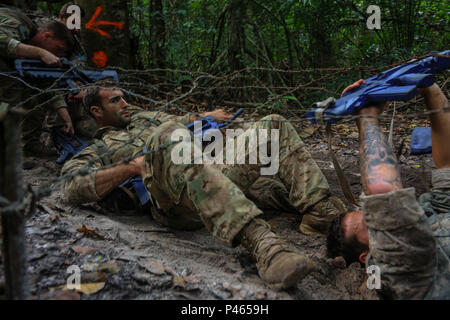 U.S. Army soldiers crawl under barbed wire during the team obstacle ...