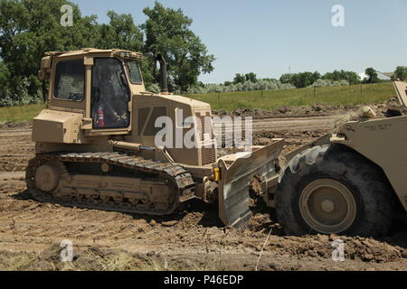 A U.S. Army 613C scraper is driven by Danish Pvt. Per Victor Sorensen ...