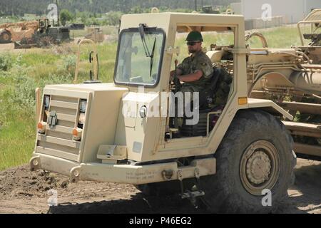 A U.S. Army 613C scraper is driven by Danish Pvt. Per Victor Sorensen ...