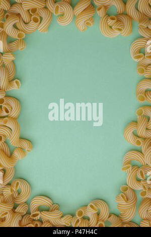 Frame of the pasta penne rigate on blue background Stock Photo - Alamy