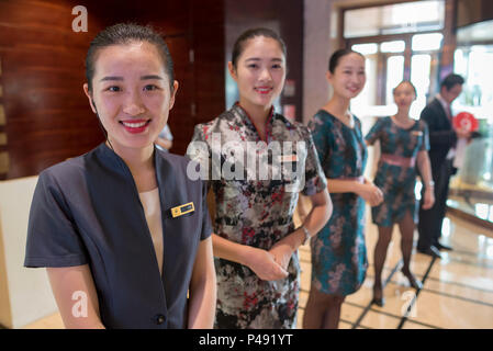 Luxury hotel staff greet foreign visitors in lobby, Beijing, China ...