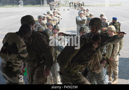 Gabonese Armed Force’s jumpmasters check the parachutes of U.S. Army ...