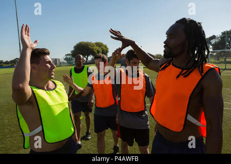 Happy Football Players Giving High Five At Field. Soccer Players High ...