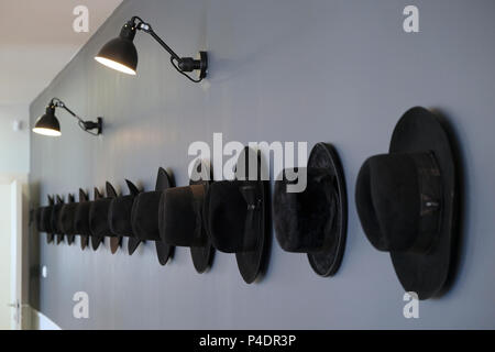 Traditional black Haredi hats hanging on a wall in a corridor of an ...