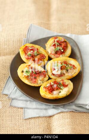 Baked potatoes with bacon and cheese on a plate.Grilled potatoes with ...