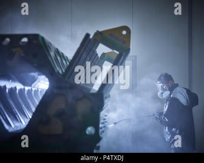 Worker cleaning engine block in washing bay Stock Photo - Alamy