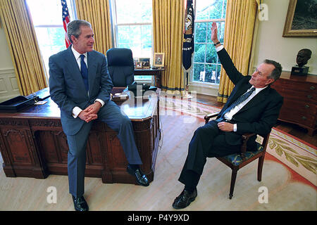President George H.W. Bush at his desk in the Oval Office of the White ...