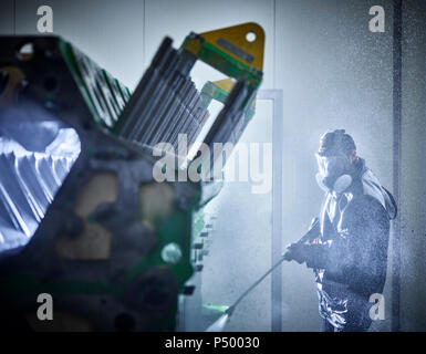 Worker cleaning engine block in washing bay Stock Photo - Alamy