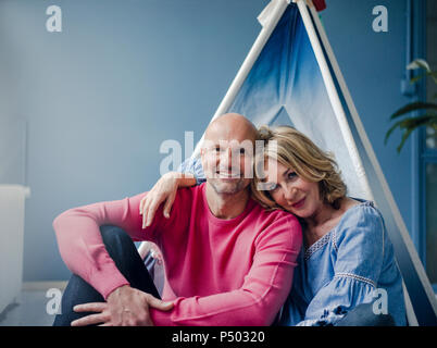Portrait of smiling couple at teepee indoors Stock Photo - Alamy