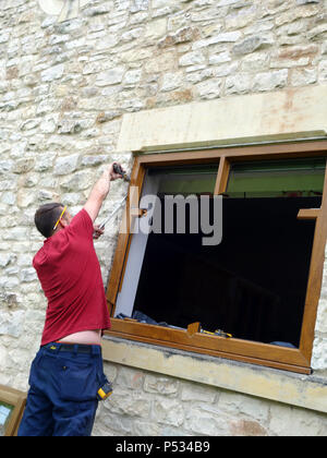 Window fitter replacing old double glazed uPVC window frames with new ...