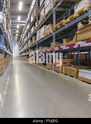 Interior view of aisles in a large warehouse stacked with cardboard ...