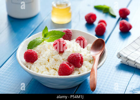 Tvorog, cottage cheese or ricotta with raspberries in bowl on blue ...