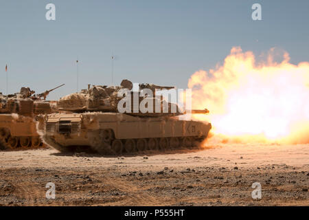 The crew of an M1A2 Abrams Main Battle Tank fires their main gun at a ...