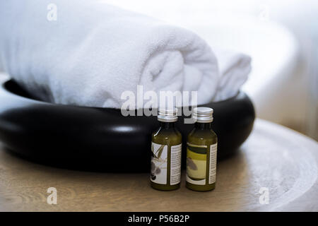 White towel and massage bath oil on table in bathroom. Abstract SPA ...