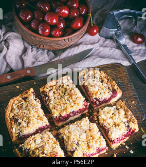 square wooden cutting board with cherry tomatoes, cheese and spices on ...