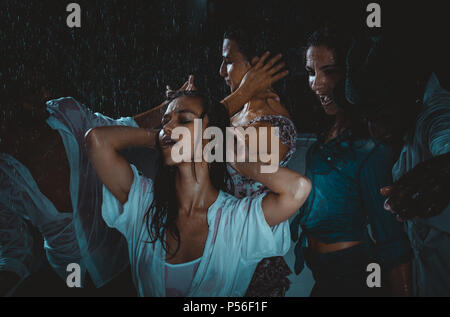 Groupof friends dncing in the rain Stock Photo - Alamy