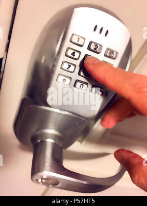 Man pressing buttons on keypad to open steel safe, closeup. Binary code symbolizing digital lock ...