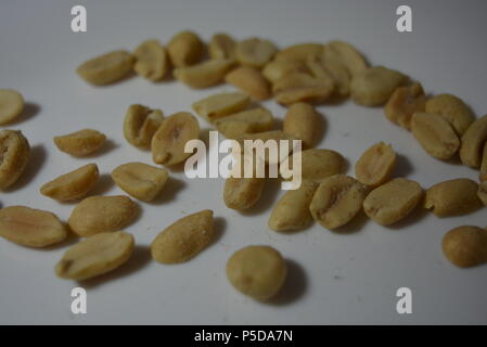 Healthy food, nuts, lots of toasted peanuts placed on a white ...
