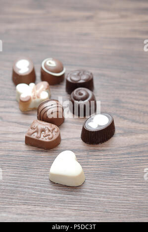 A variety of small chocolates on a wooden background Stock Photo - Alamy