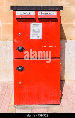 Red letterbox with slots for local and foreign mail and collection ...