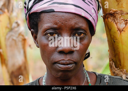 A Hutu woman and a Tutsi women who are friends stand outside a house ...