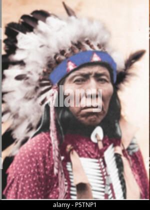 A colorized historical photograph of a Native American leader kneeling ...