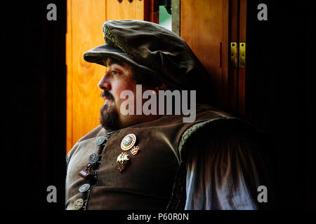A Renaissance fair actor dressed as a nobleman poses with his beer ...