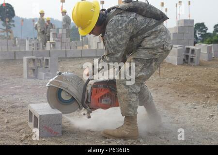 U.S. Army Sgt. Dean Poyner uses a buzzsaw to create incisions in a ...