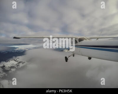 Airplane flying over the beautiful Canadian Mountain Landscape during a ...