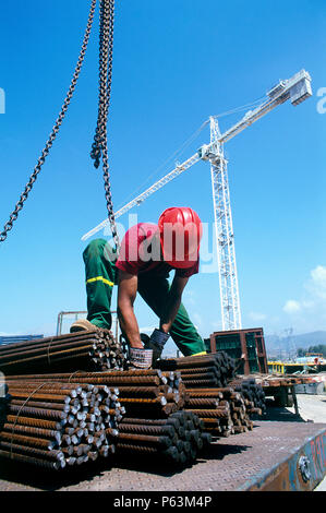Unloading steel reinforcement bundle from lorry by crane on a ...