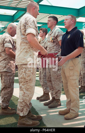 Maj. Daniel Lammers, Combat Center Provost Marshal, awards Sgt. Russell Harned, watch commander ...