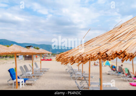Reed umbrellas beach with blurred beach Stock Photo - Alamy