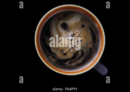 Freshly poured black coffee with froth in white ceramic cup next to a ...