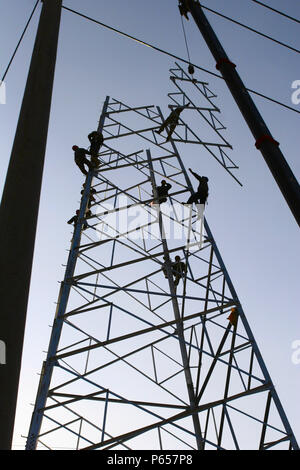 Construction workers erect a power grid at a height at the Shaanxi ...