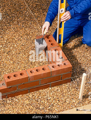 Bricklayer checking level with string line on a house building site ...