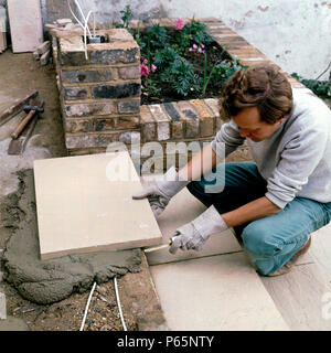 Laying slabs on a garden terrace, building a veranda, a floor made of ...