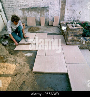 Laying slabs on a garden terrace, building a veranda, a floor made of ...