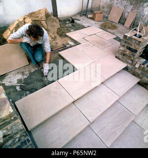 Laying slabs on a garden terrace, building a veranda, a floor made of ...