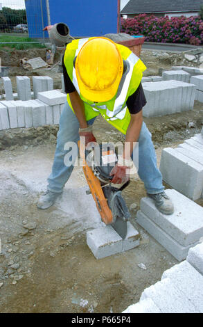 Builder cutting concrete slabs with petrol concrete saw and a diamond ...