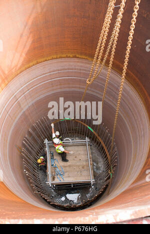 Crane lifting steel reinforced cage into an excavated pile. Concrete ...