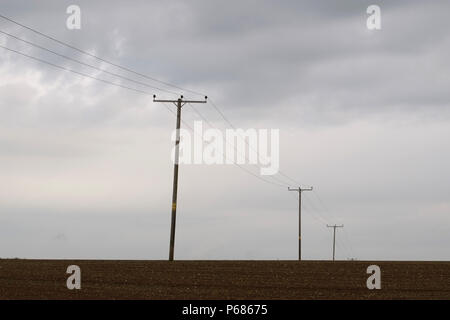 Telephone wires strung across a remote field Stock Photo - Alamy