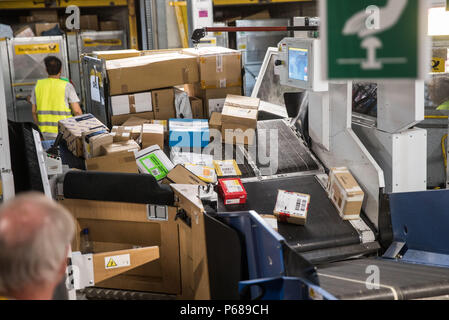 28 June 2018, Germany, Obertshausen: Parcels travel through a scanner ...