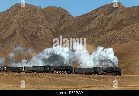 A China Railway's QJ Class 2-10-2 approaches Sankong Bridge. The vast ...