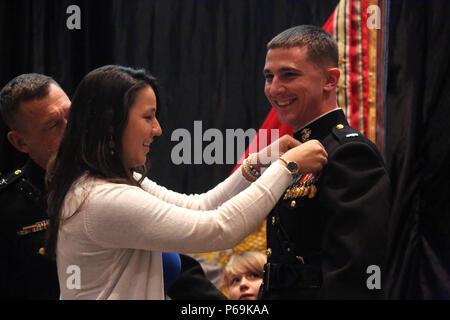 A Marine Corps aviator is pinned by his wife during a winging ceremony ...