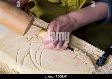 Wood carving. Carver with chisel and hammer. A skillful craftsman ...
