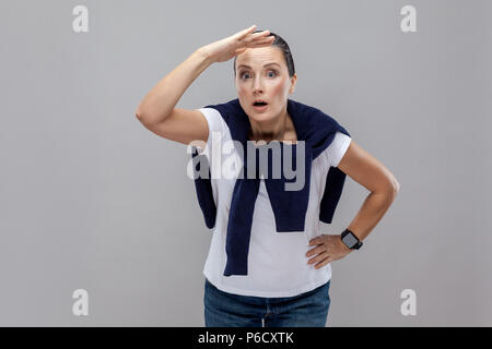 woman in gray sweater is shocked by news touches hand to cheek opens ...