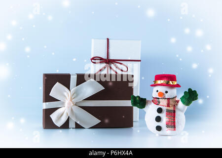 Snowman stand near gift box on white background. Snow flake is falling ...